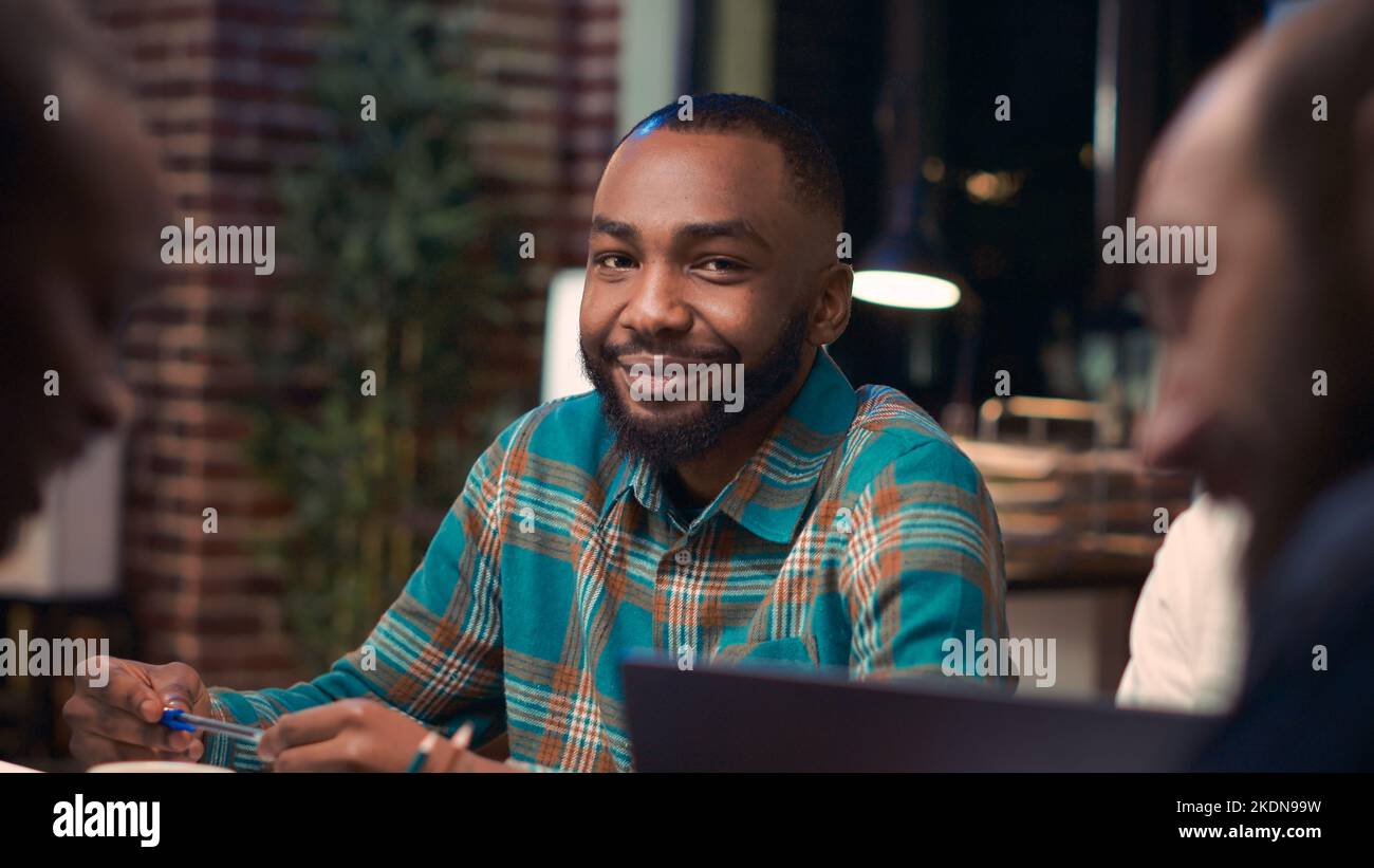 African american employee smiling portrait in business meeting, coworkers talking at boardroom ...