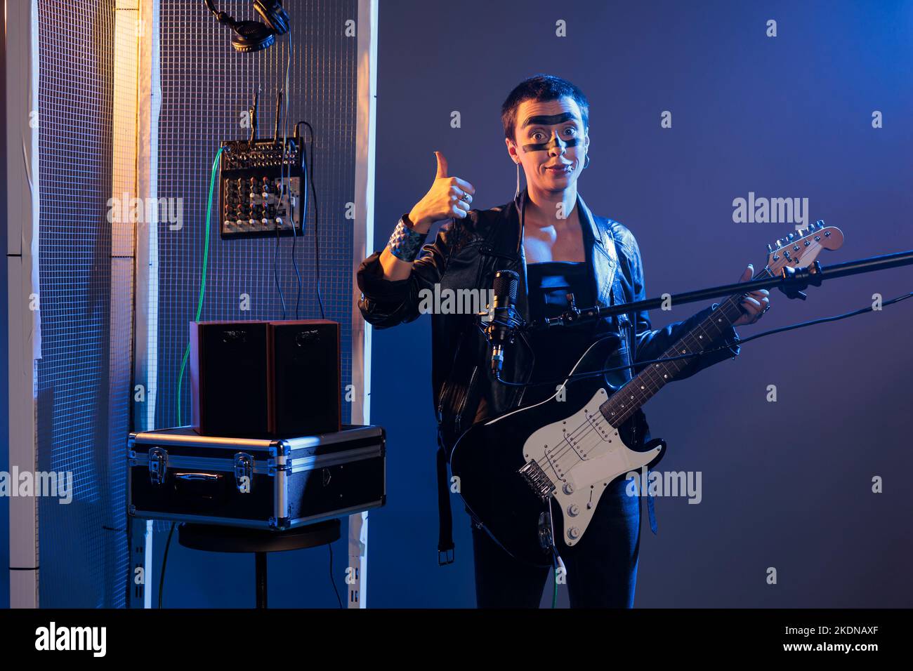 Female artist giving thumbs up in studio and doing live rock ...