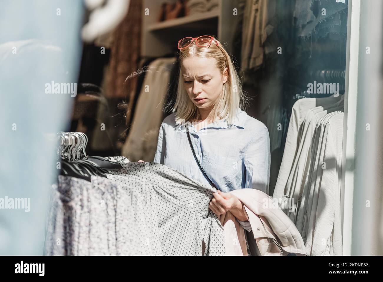 Woman shopping clothes. Female shopper looking at fashionable clothes ...