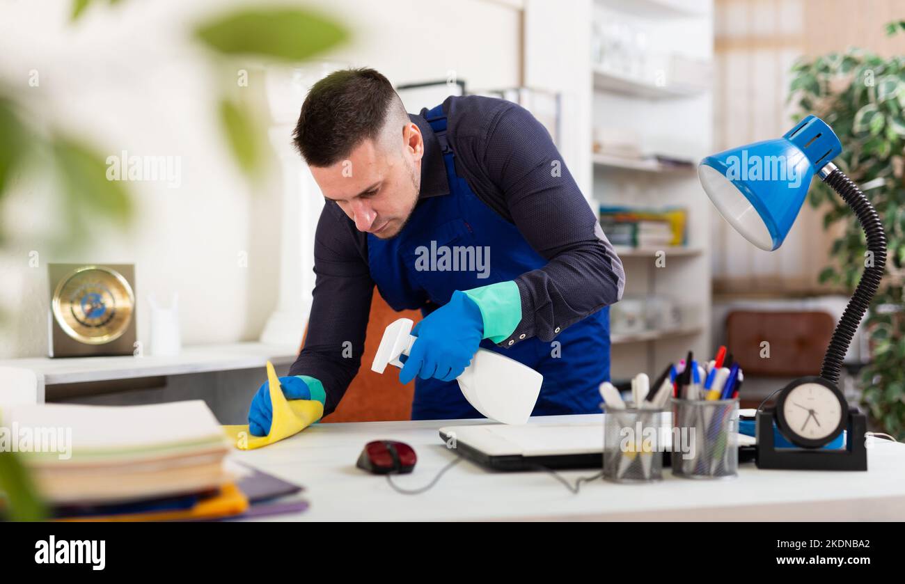 Young man cleaner working at office Stock Photo - Alamy
