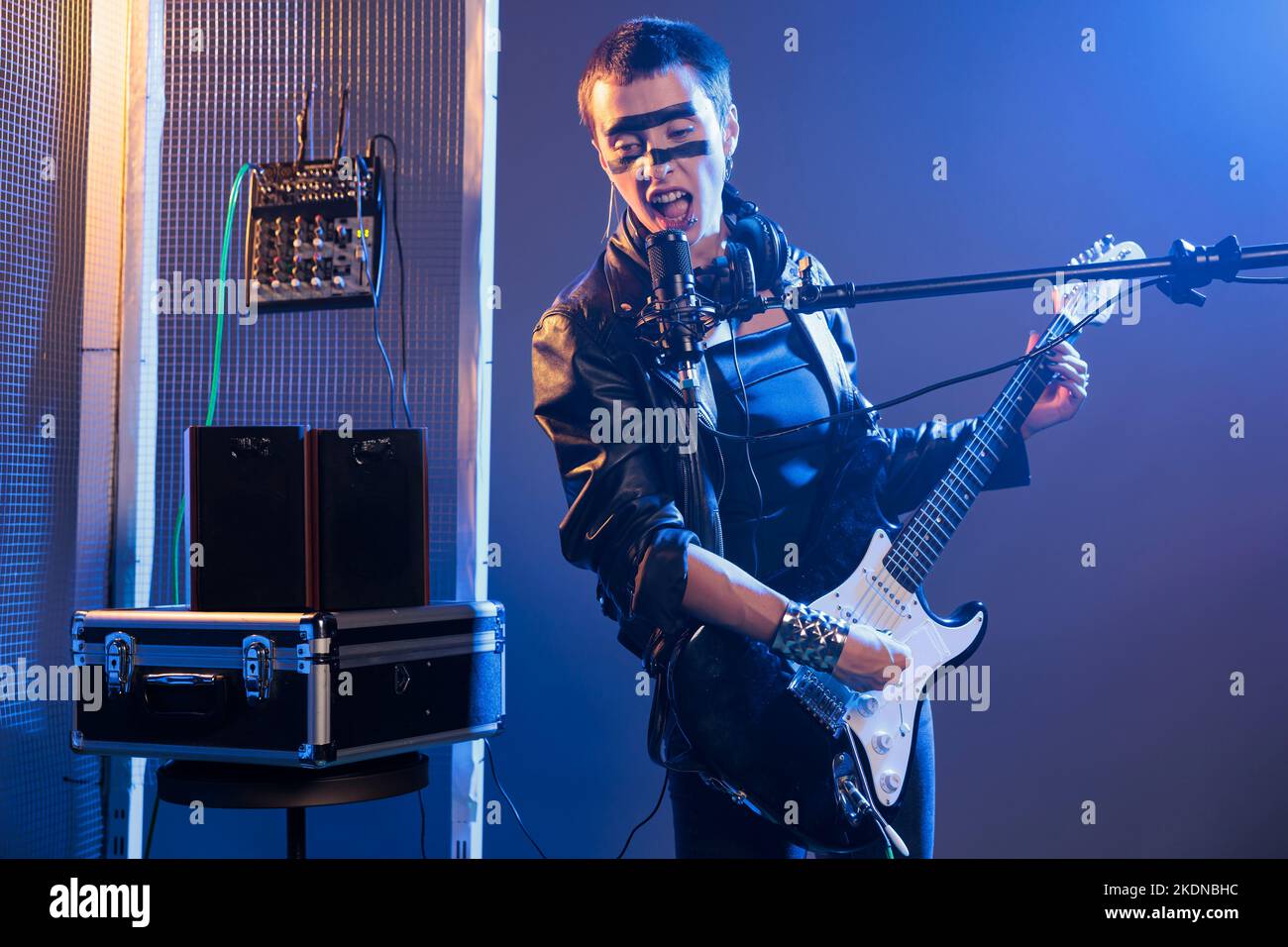 Female performer with crazy make up playing guitar, singing alternative ...
