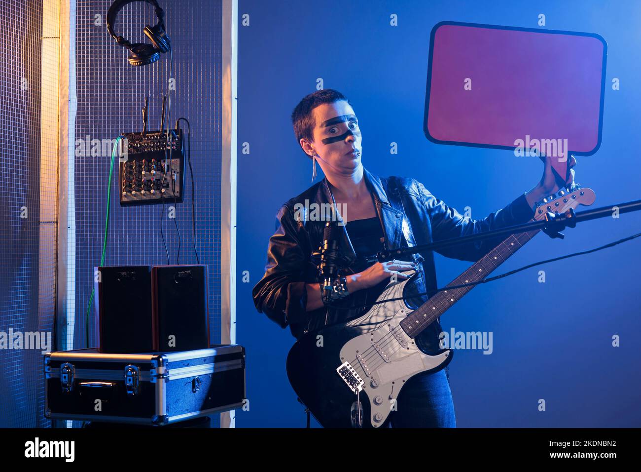 Rock artist girl holding cardboard speech bubble and guitar to ...