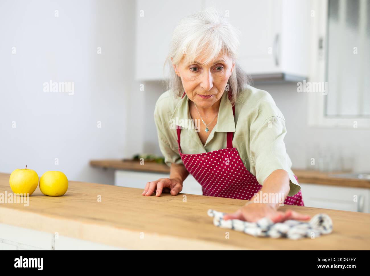 Senior woman washing kitchen table during cleanup Stock Photo - Alamy
