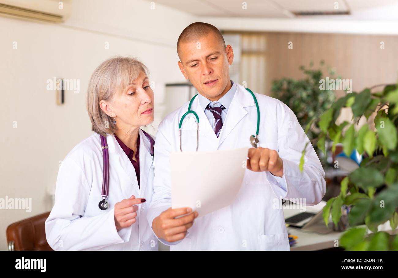 Two doctors discussing medical documentation Stock Photo - Alamy