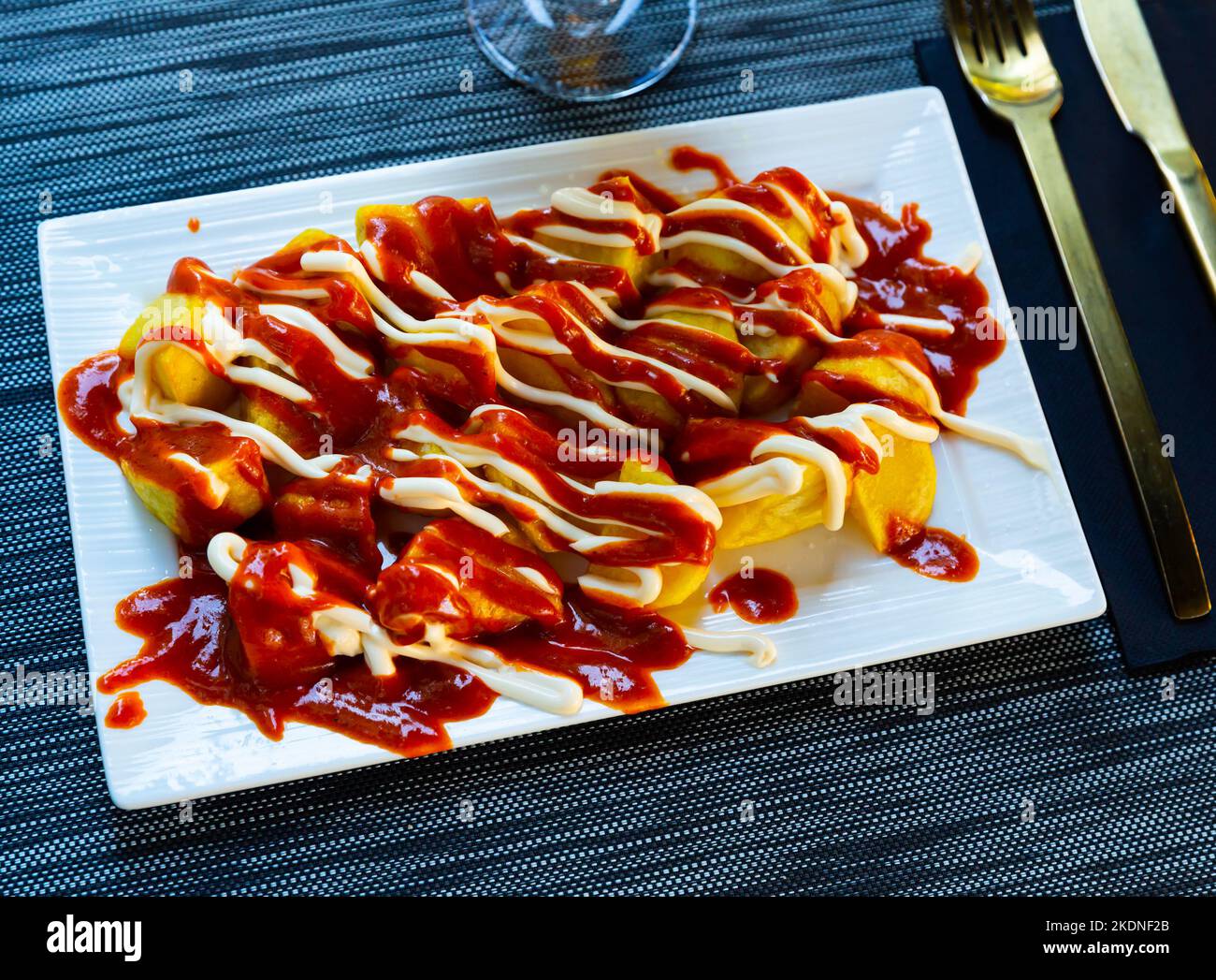 Top view of Patatas bravas, Spanish dish of fried potatoes served with ...