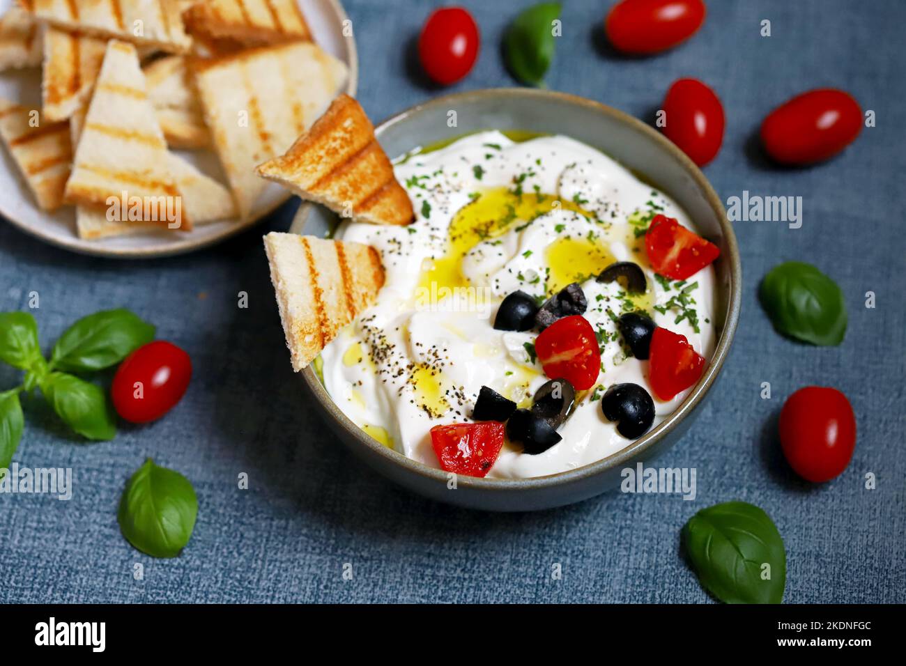 Greek yogurt dip with olives and croutons Stock Photo - Alamy