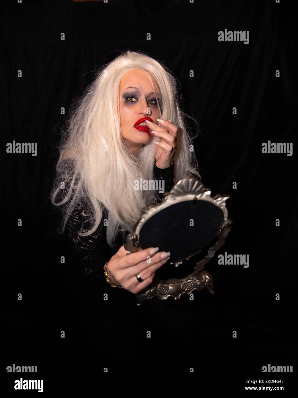 Pretty dark woman smearing makeup with a mirror Stock Photo - Alamy