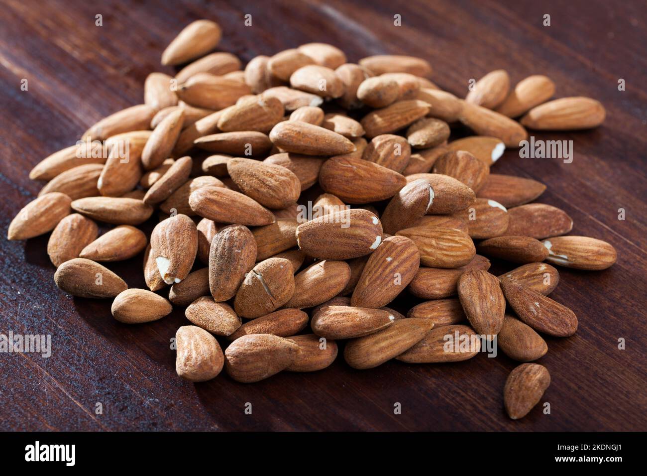 Roasted almonds on wooden table Stock Photo - Alamy
