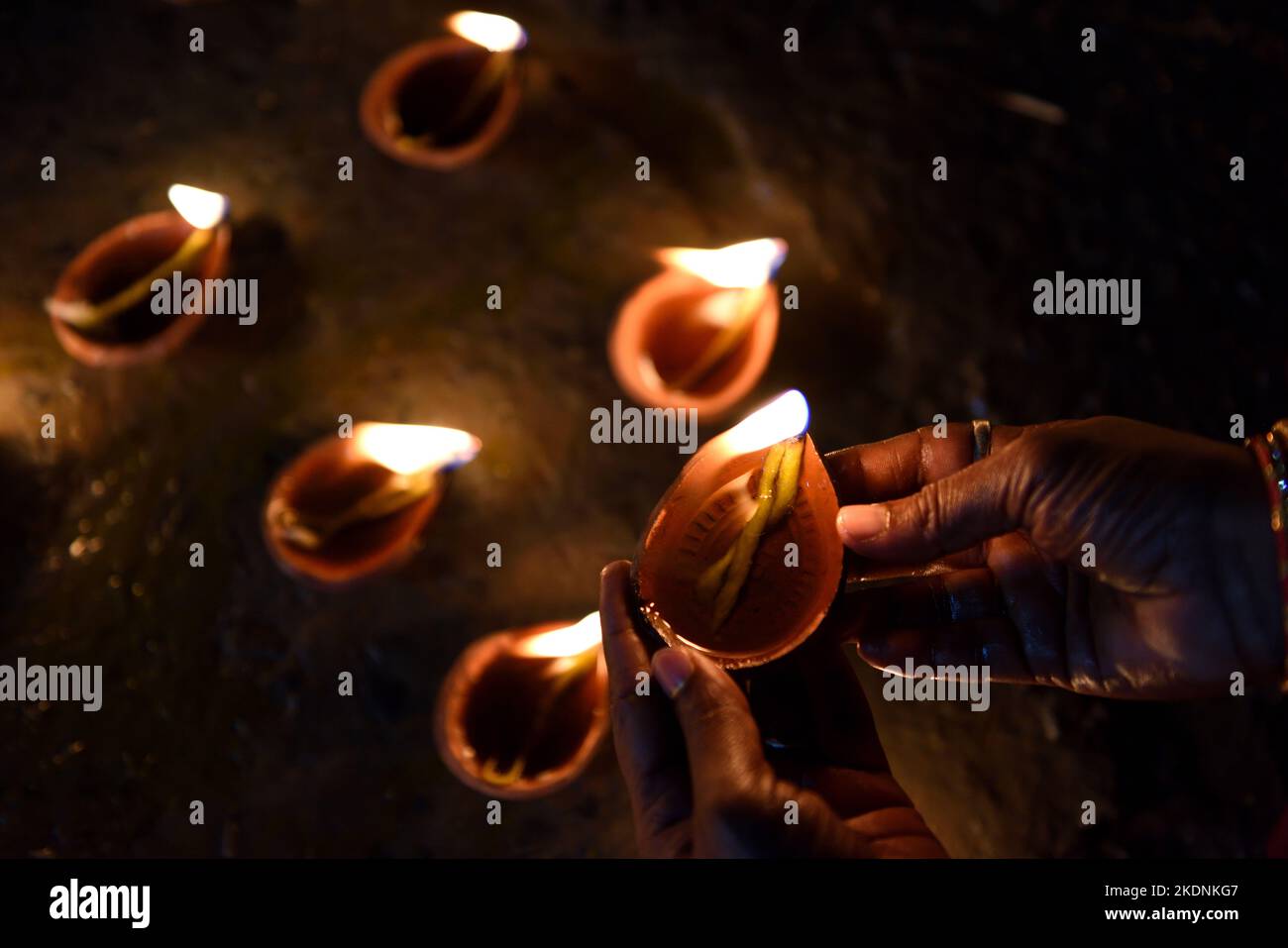 Kolkata, India. 7th Nov, 2022. A woman holds an oil lamp on the ...
