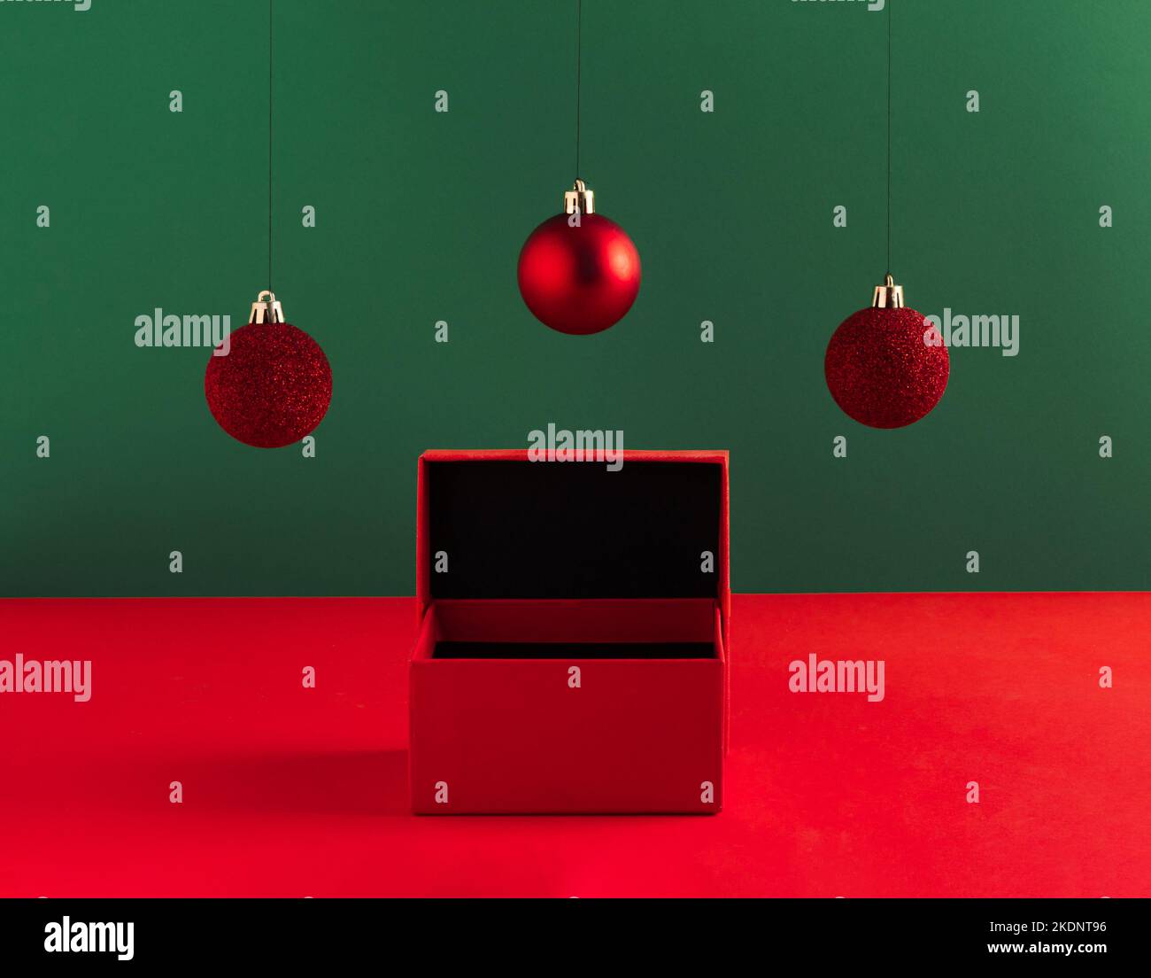 Creative Christmas concept made of gift box and red baubles on bold ...