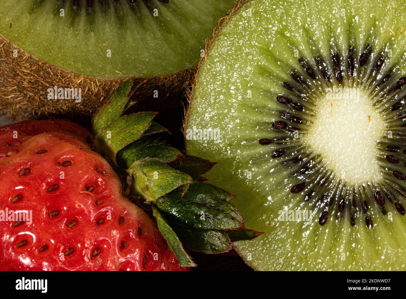 Kiwi cut in half next to a strawberry in a closed macro plane Stock ...