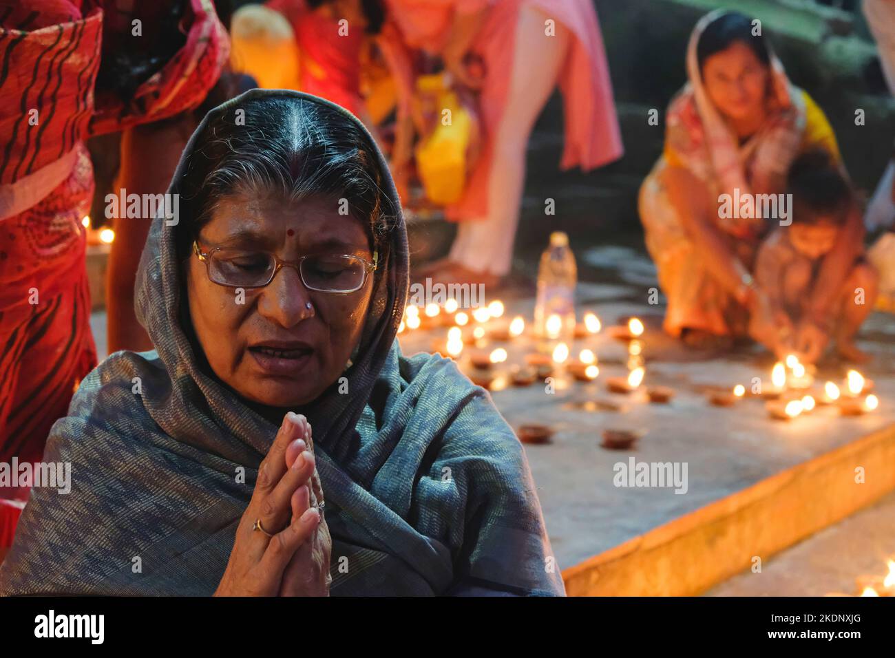A woman seen offering prayers during the occasion. Devotees are ...