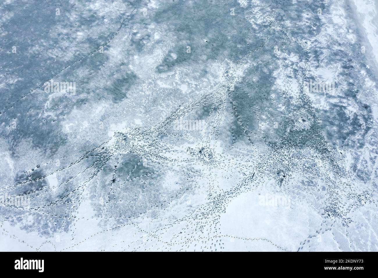 frozen lake ice texture with many different footprints. aerial drone ...