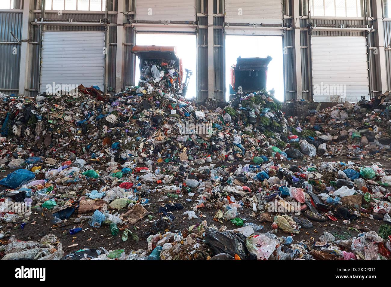 Garbage truck unloads household waste in the receiving chamber of a ...