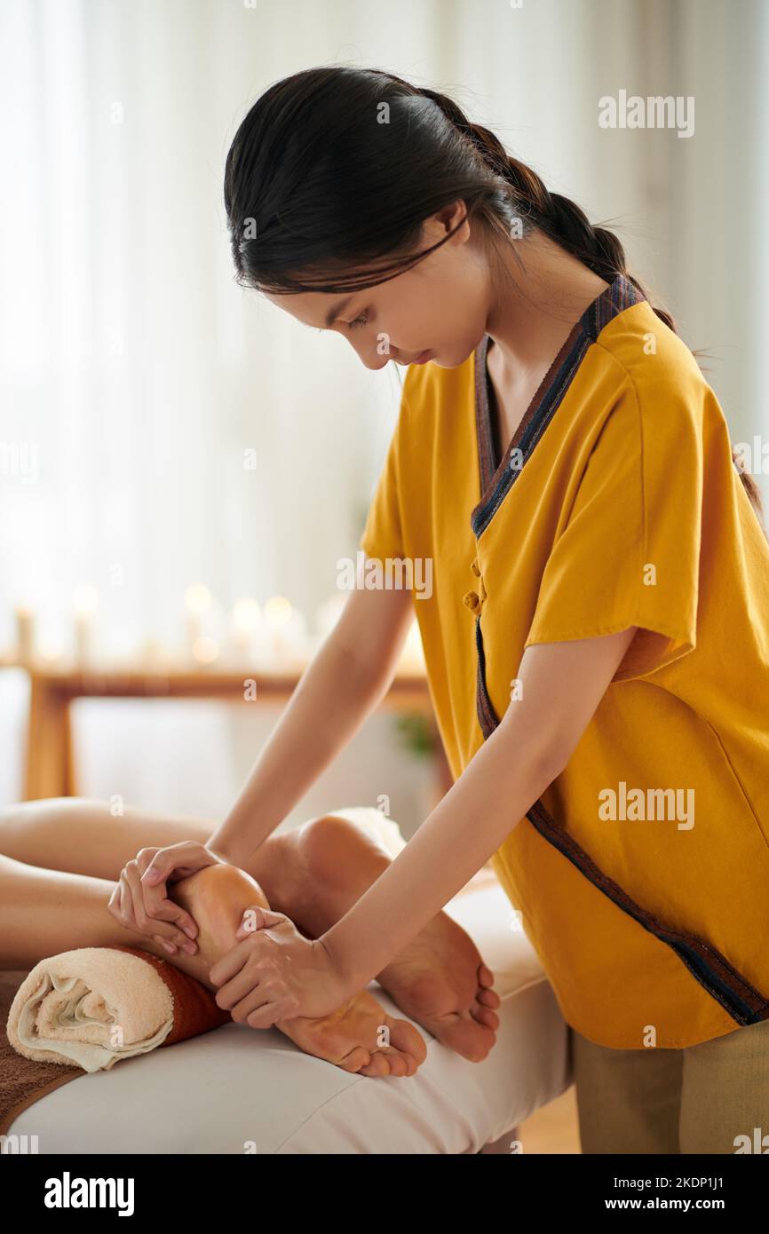 Masseuse making pushing movement when massaging feet of woman Stock ...