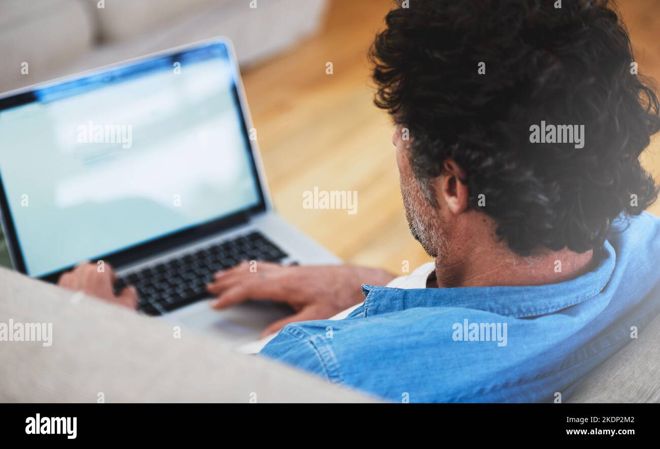 Exploring the world wide web. Rearview shot of a bachelor relaxing on ...