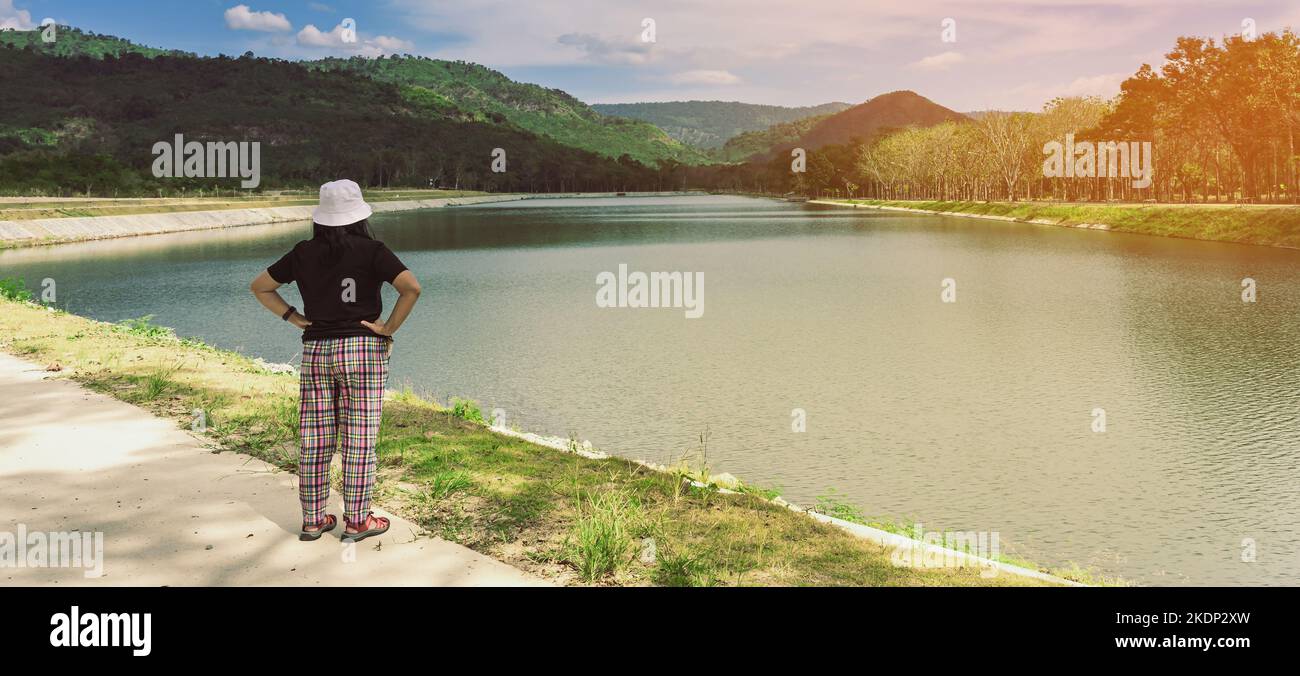 Back view of woman wear hat enjoy the beautiful and peaceful view of ...