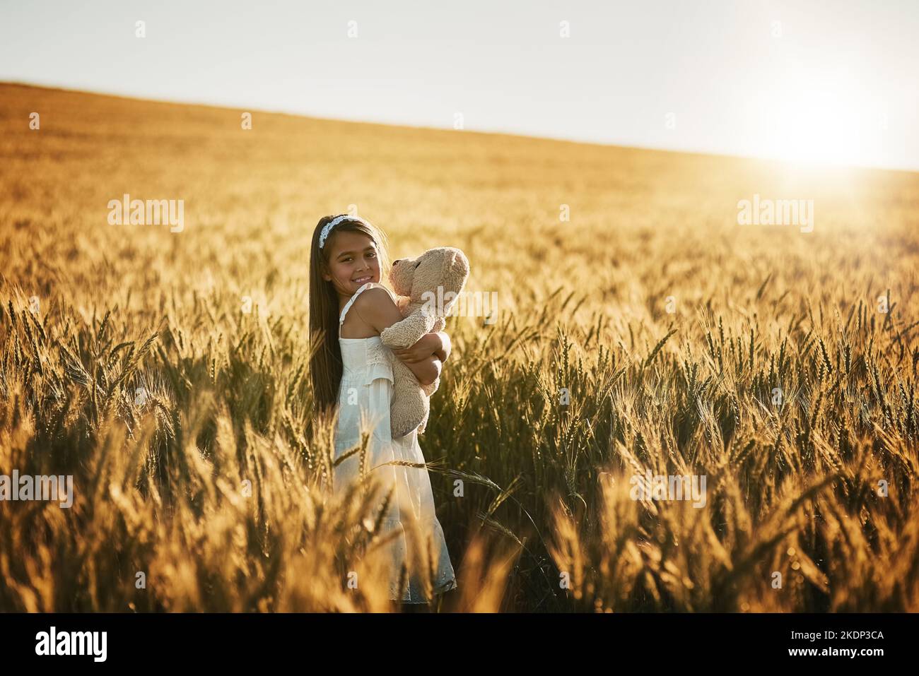 Nature is her playground. Portrait of a cute little girl playing with her teddybear in a ...