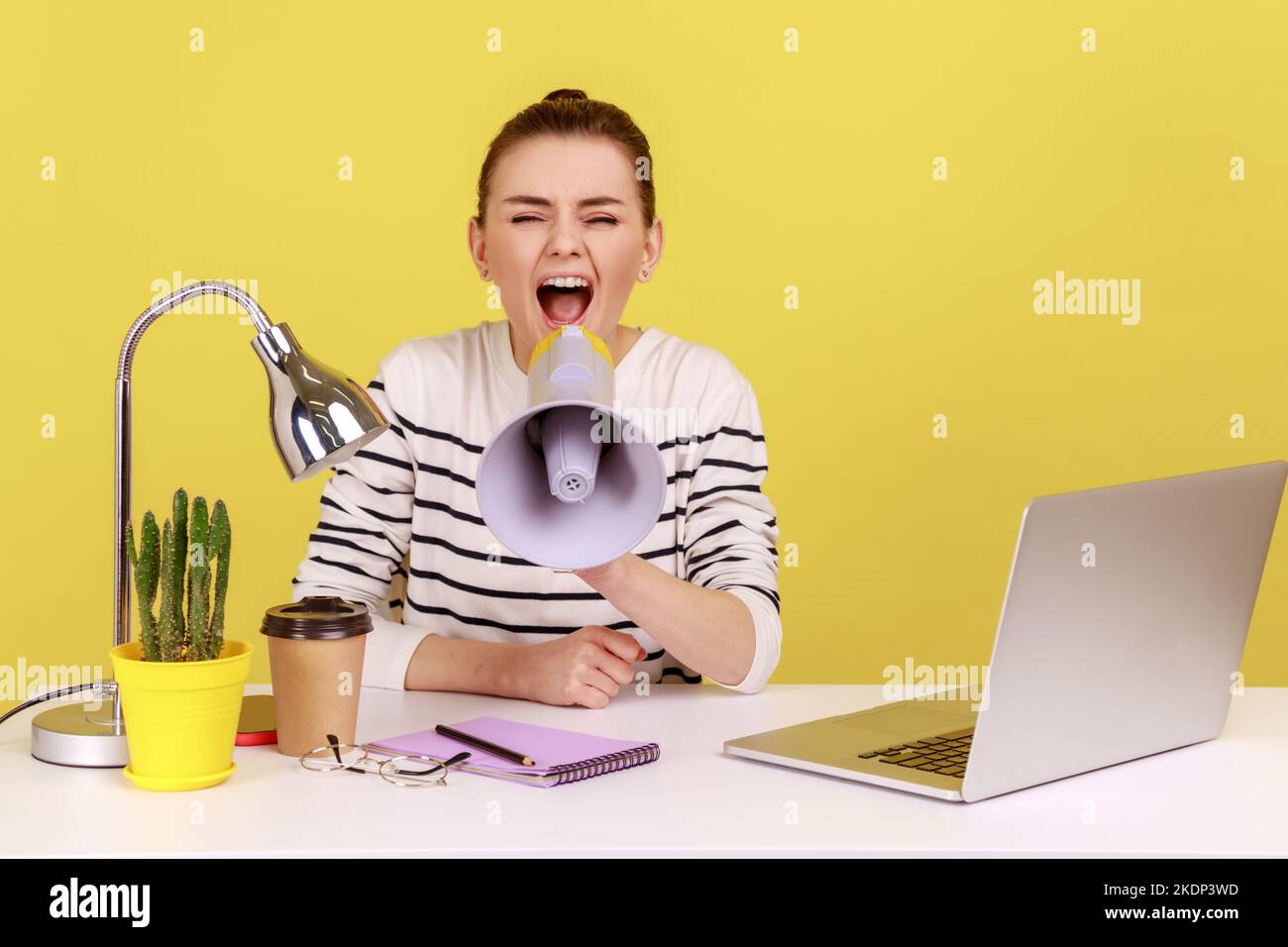 Portrait of young adult attractive woman screaming loudly in megaphone ...