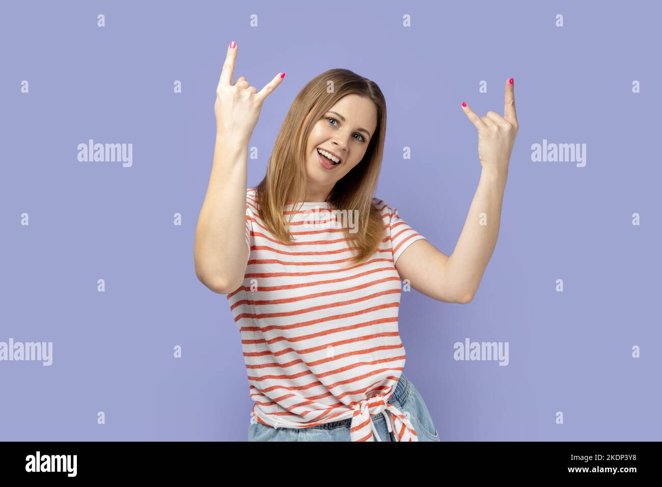 Yeah, awesome. Excited rocker blond woman wearing striped T-shirt ...