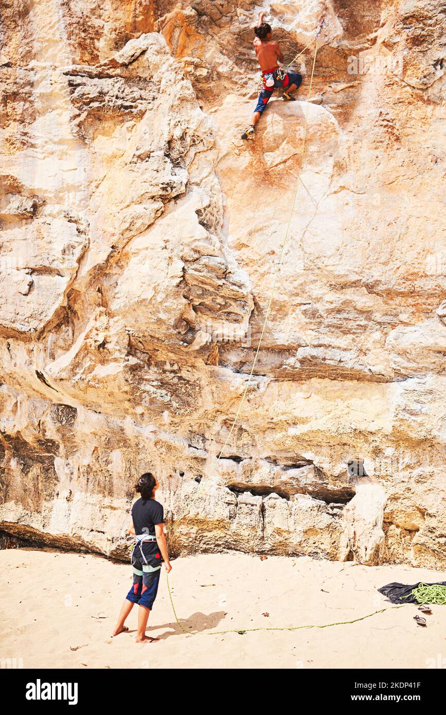 In pursuit of a great adventure. two young people rock climbing on a ...