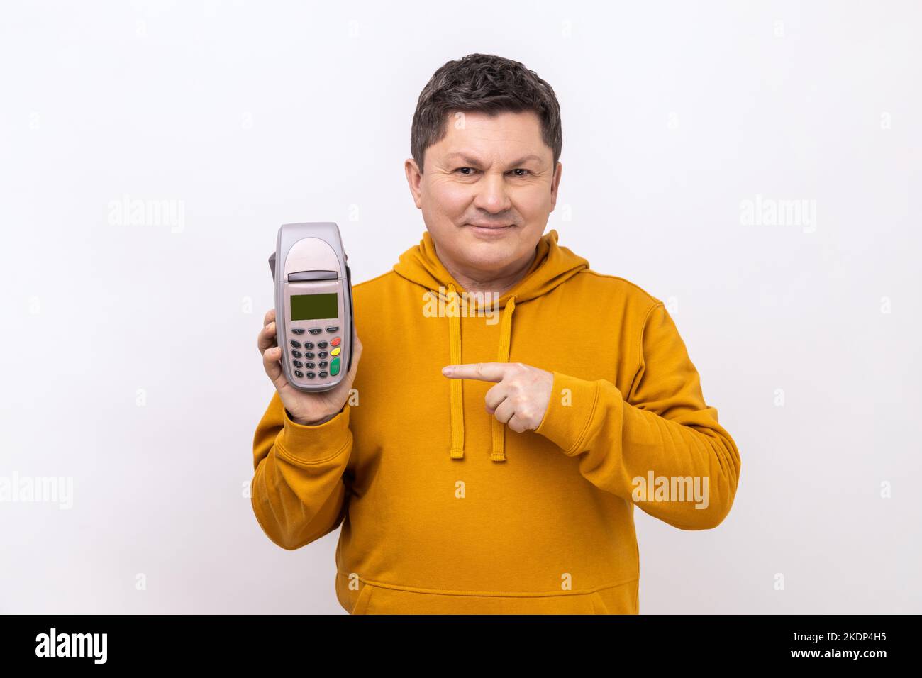 Smiling positive man holding and pointing at pos payment terminal ...