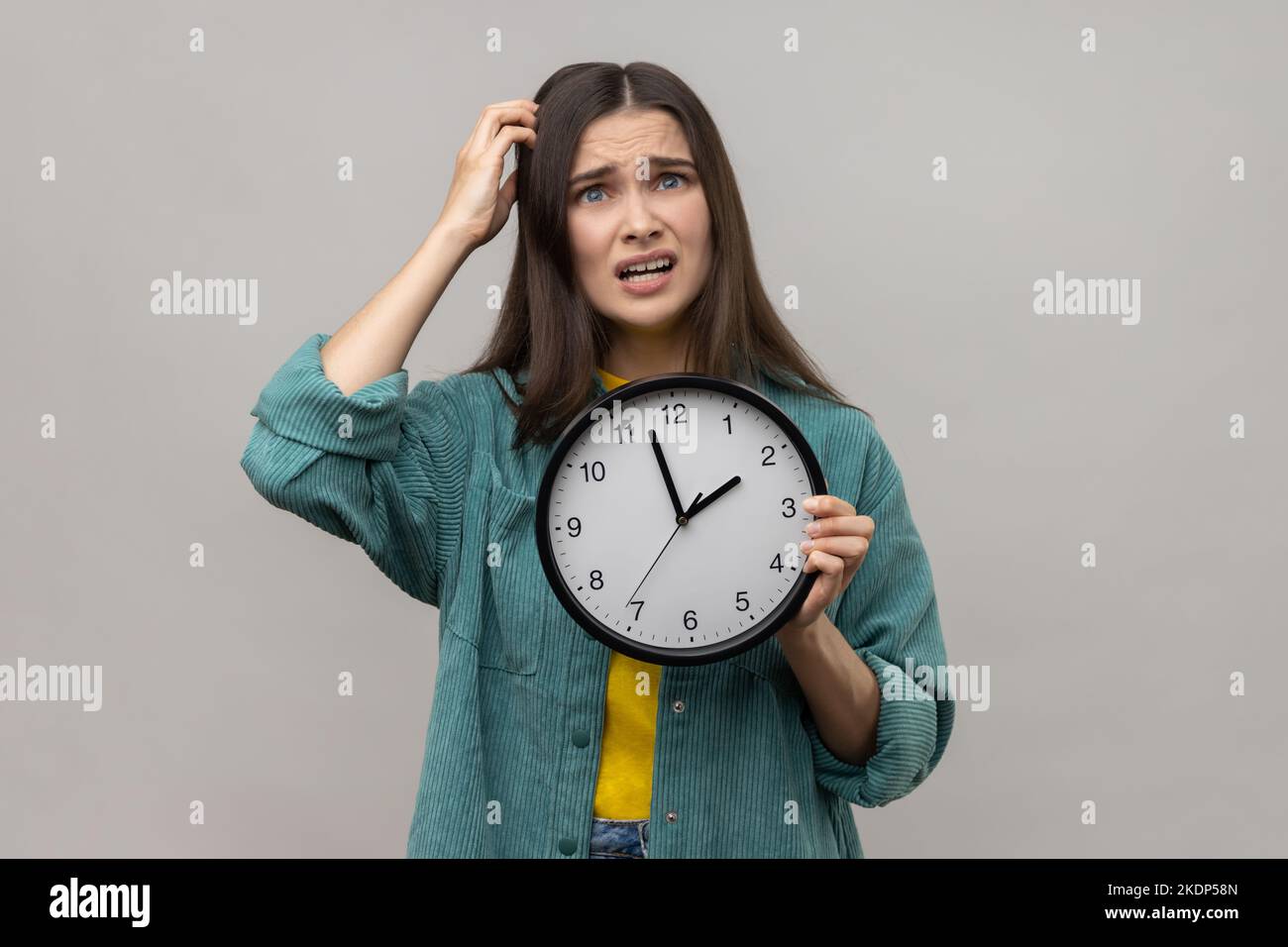 Confused woman with dark hair rubbing her head holding in hands big ...