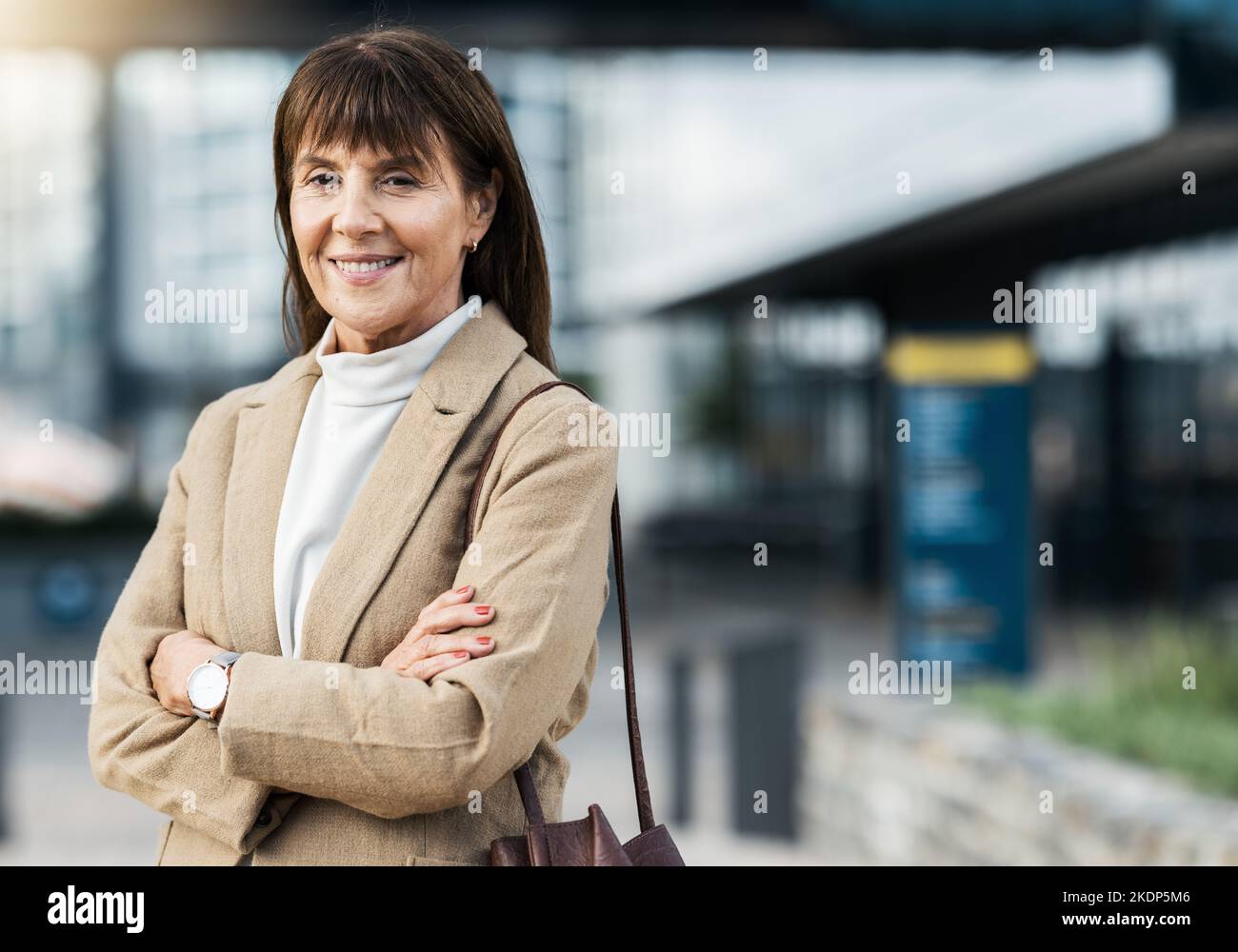 Senior portrait of confident business woman with smile, crossed arms ...