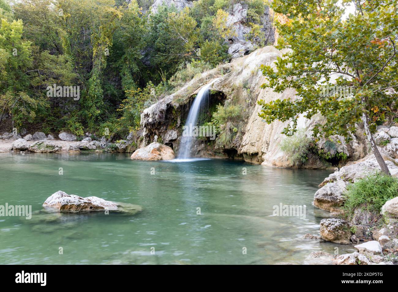 Water cascading over rocks into a natural pool at Turner Falls in ...