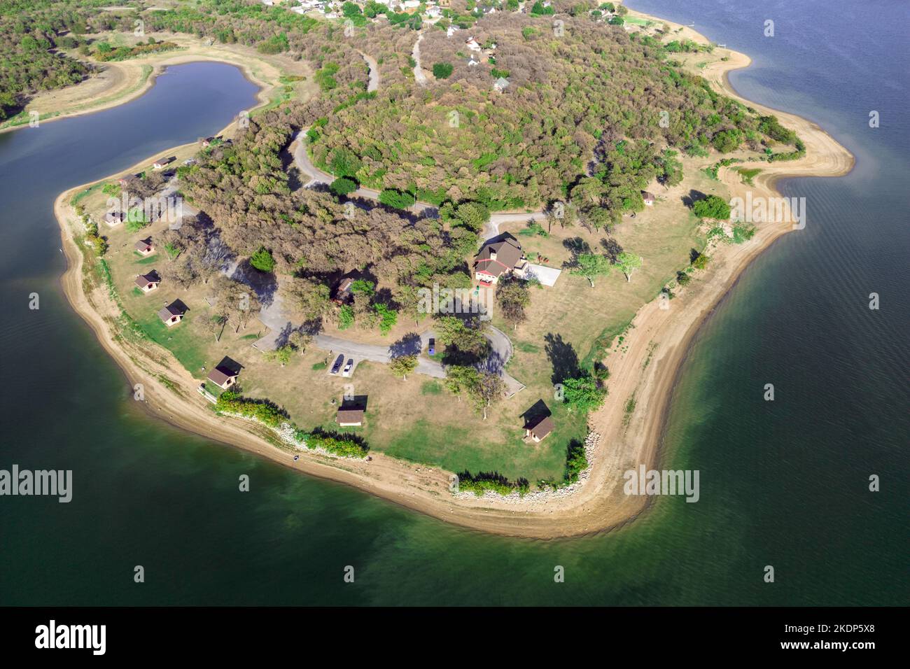 Aerial view of island with green trees, settlements and roads ...