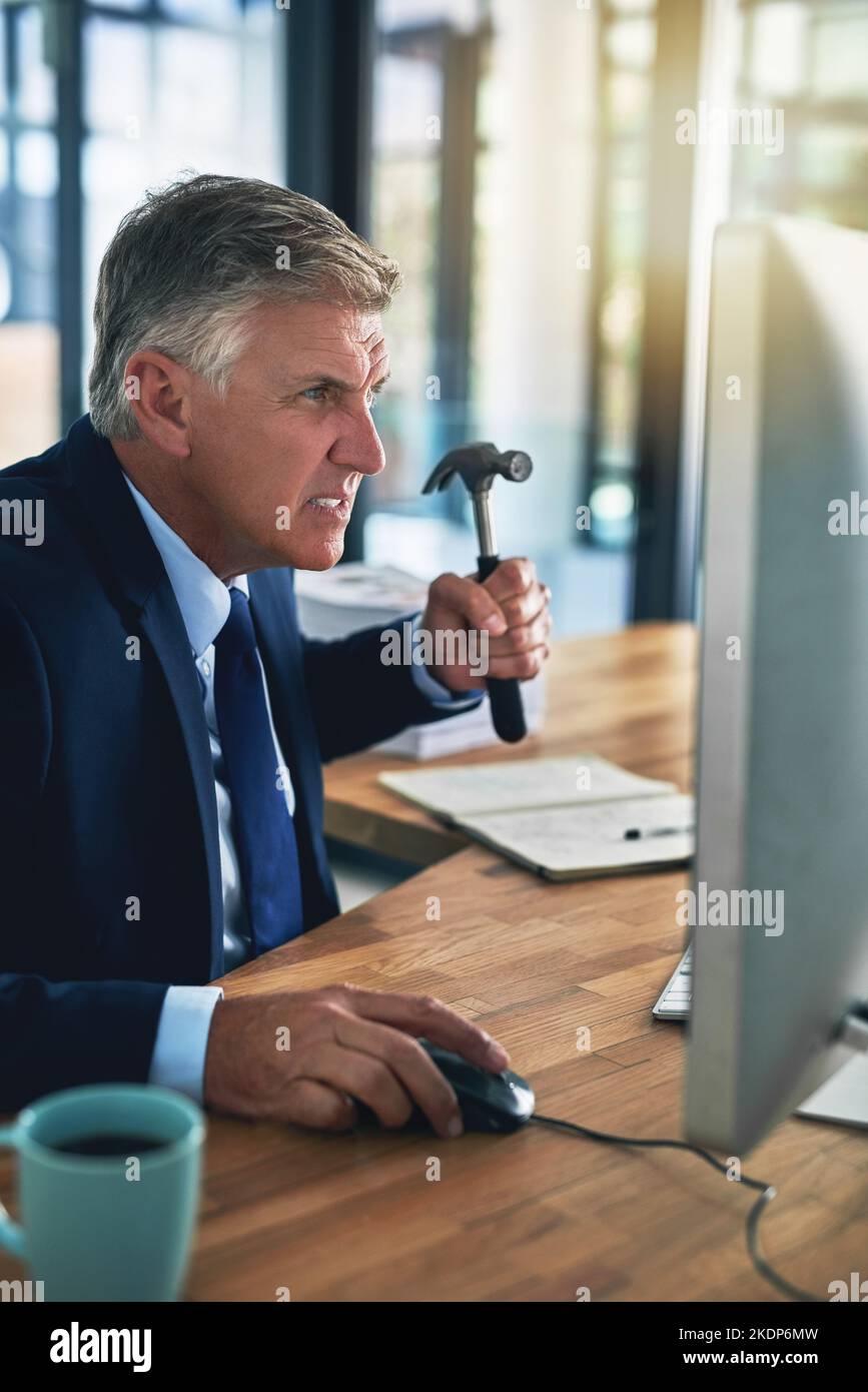 Time for a hard reset. a frustrated businessman threatening to hit his ...