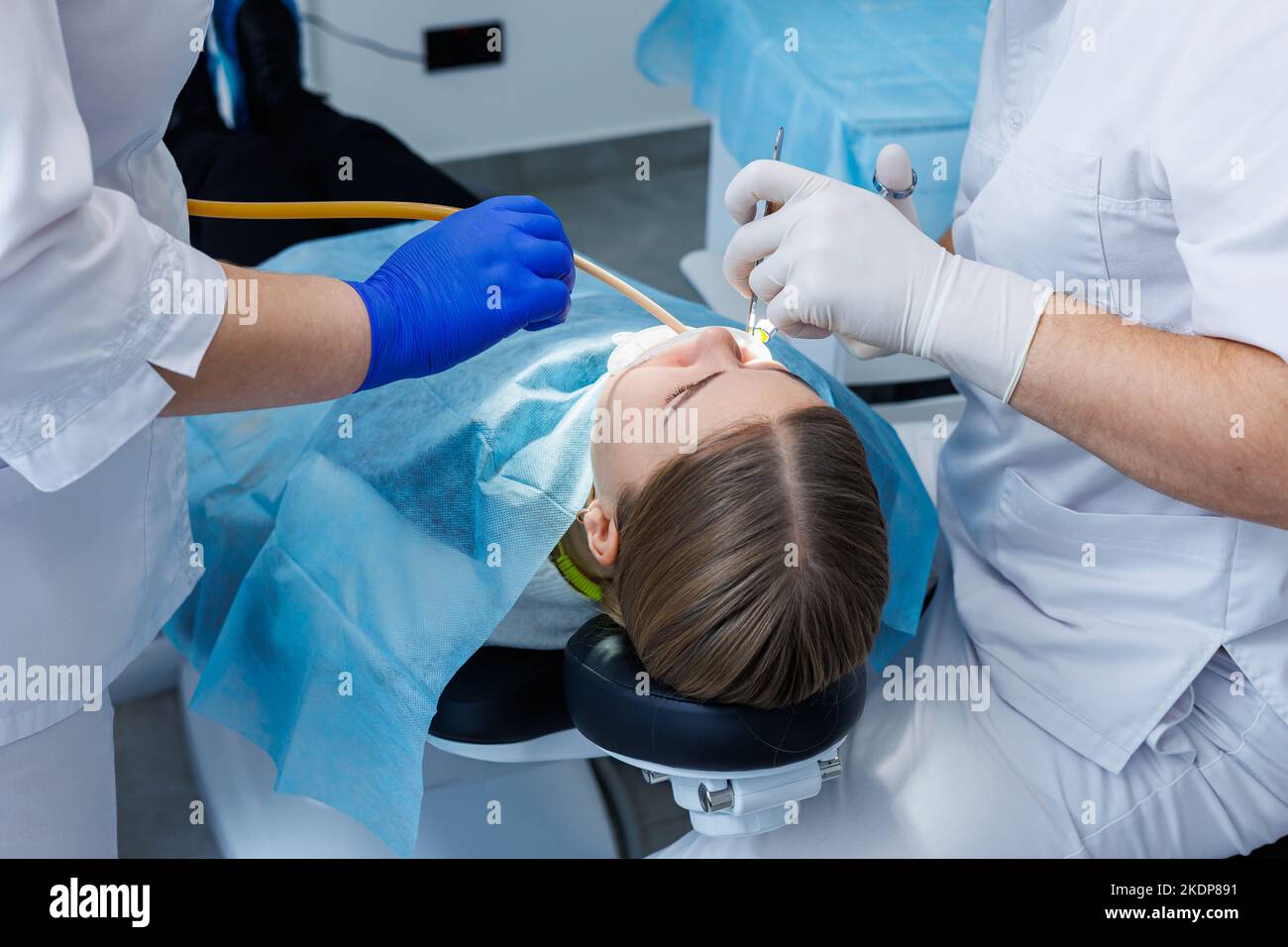 The dentist examines the patient's teeth using dental equipment. Modern ...