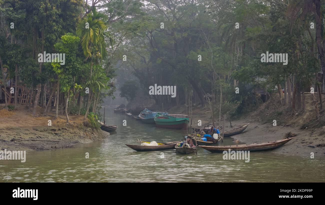 Landscape view in the morning haze of fishing boats on the water in green environment ...