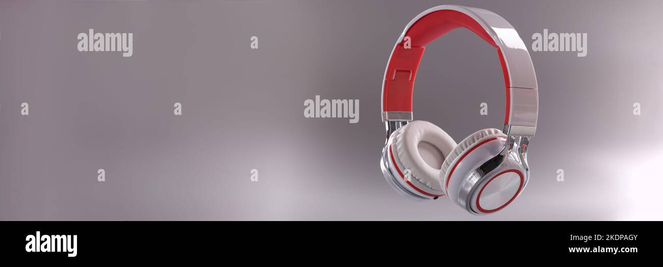 Modern headphones in red and white colour combination on grey ...