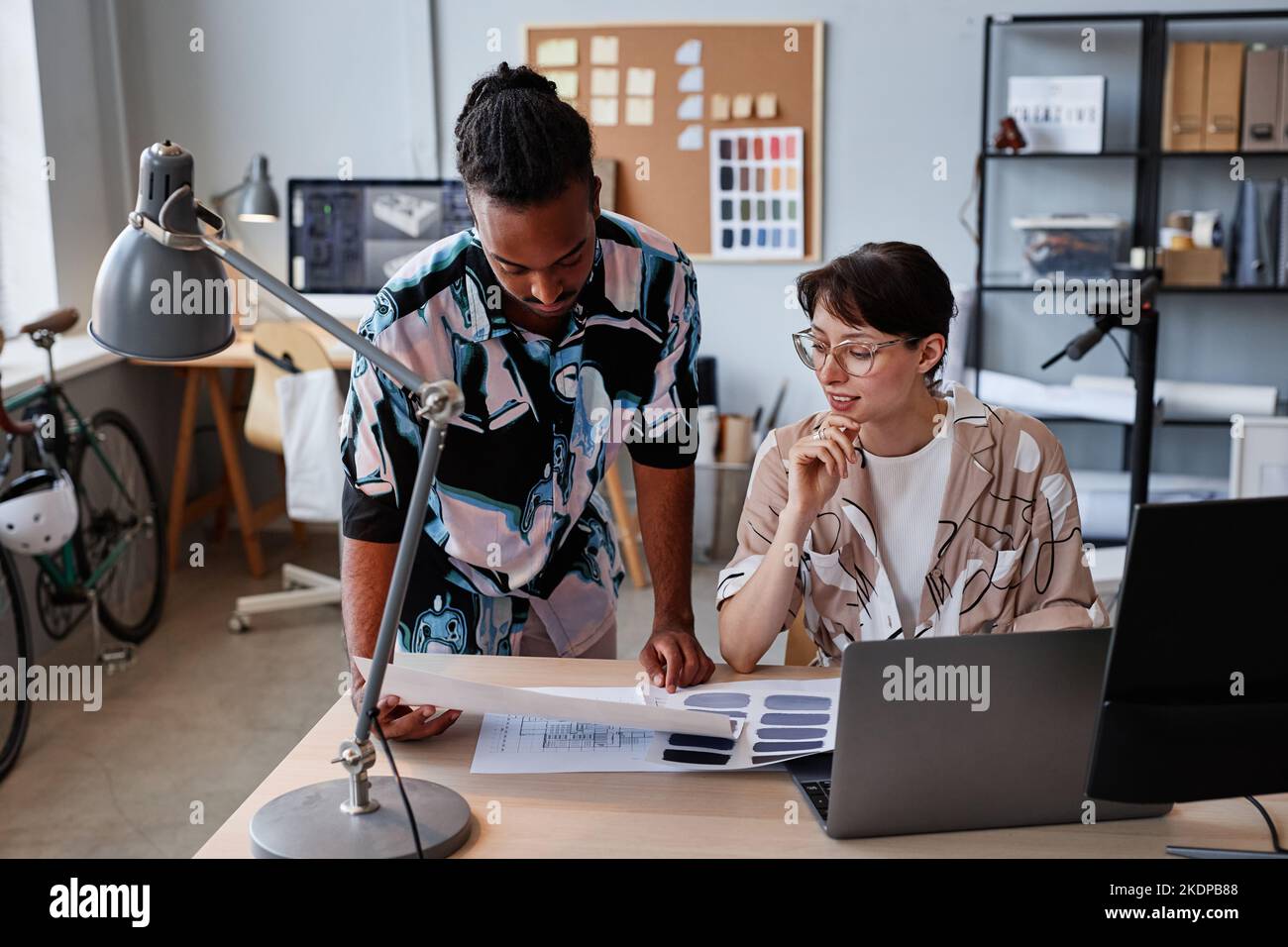 Portrait of two creative young people choosing color palette while ...