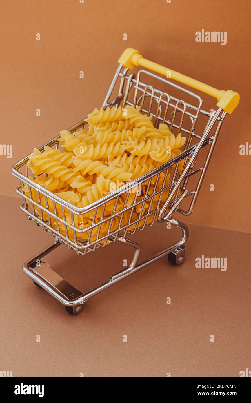 Shopping trolley cart Filled With Pasta on Beige background. Copy space ...