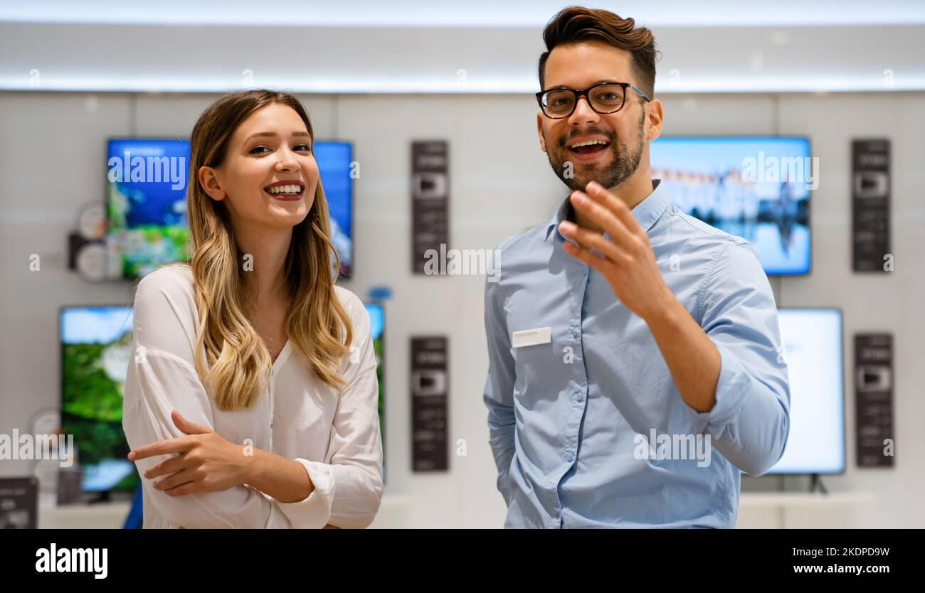 Portrait of salesman helping to woman to buy a new digital device in tech shop Stock Photo - Alamy