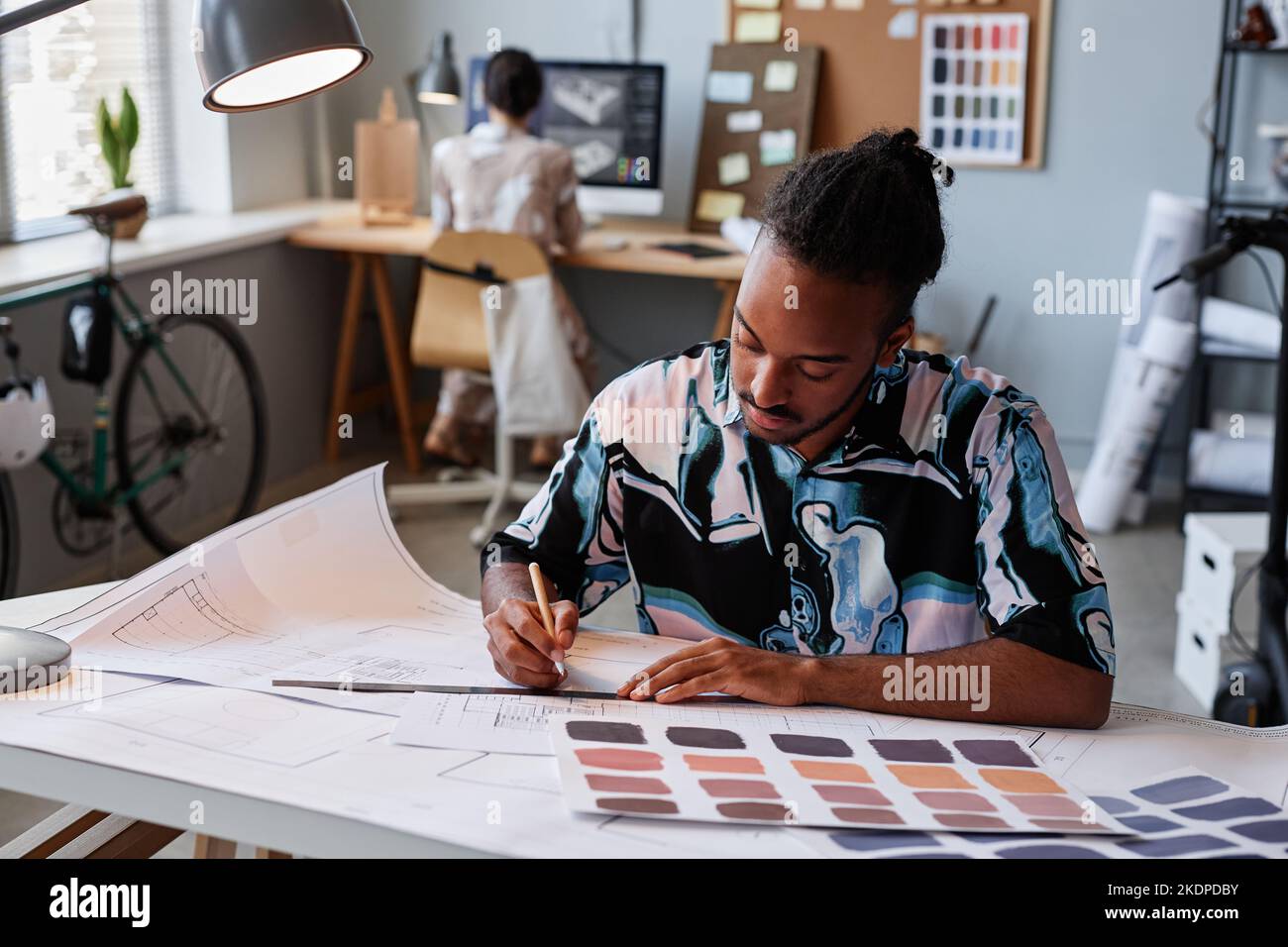 Portrait of creative black man working on floor plans for interior ...