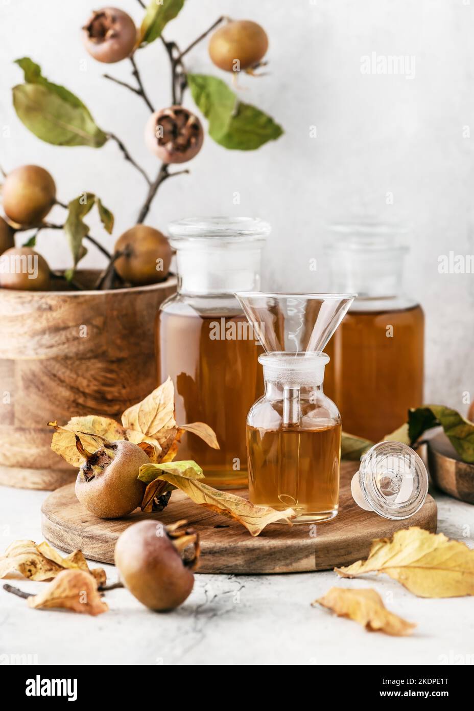Homemade medlar syrup or juice in three pharmacy glasses with fresh ...