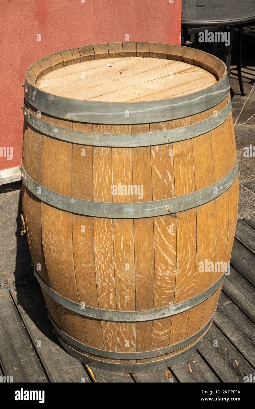A large wooden barrel stands on the street near the building as a ...