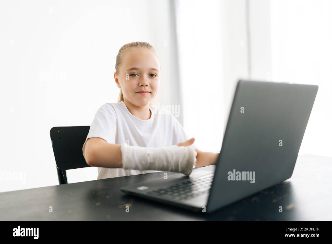 Cheerful little girl with broken hand wrapped in white plaster bandage ...