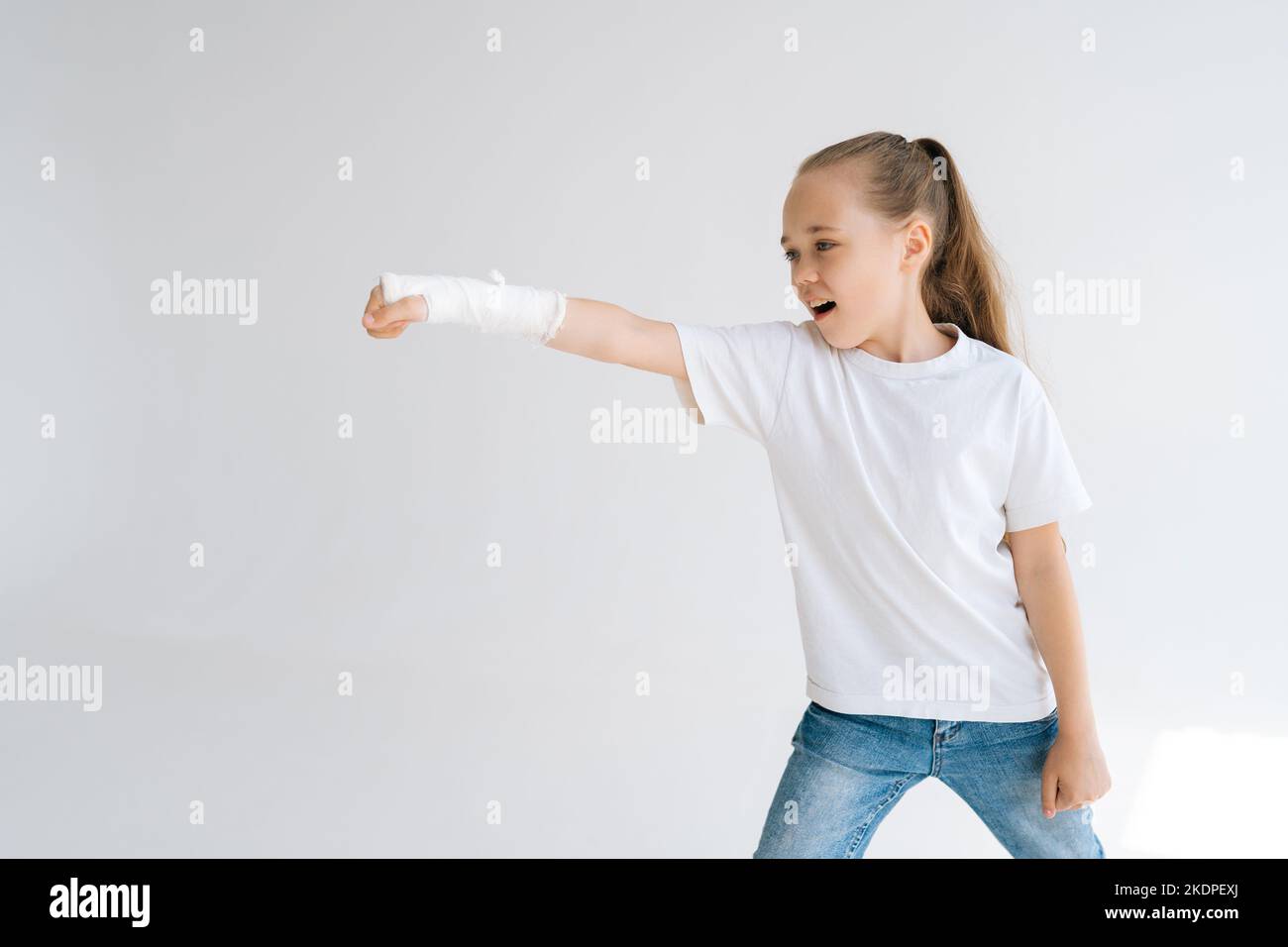 Portrait of smiling cute little girl with broken hand wrapped in white ...