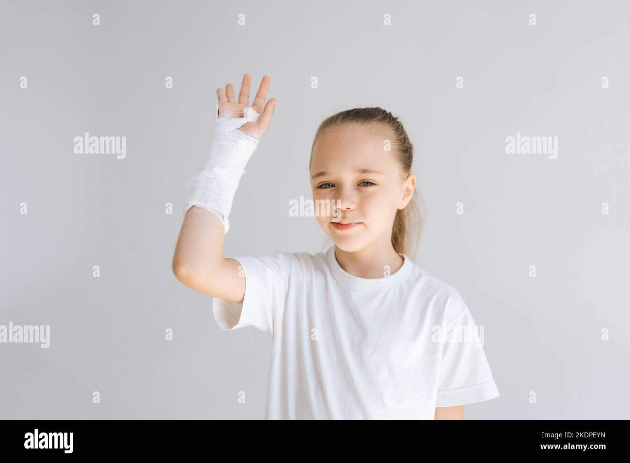 Medium shot portrait of cheerful little girl with broken hand wrapped ...