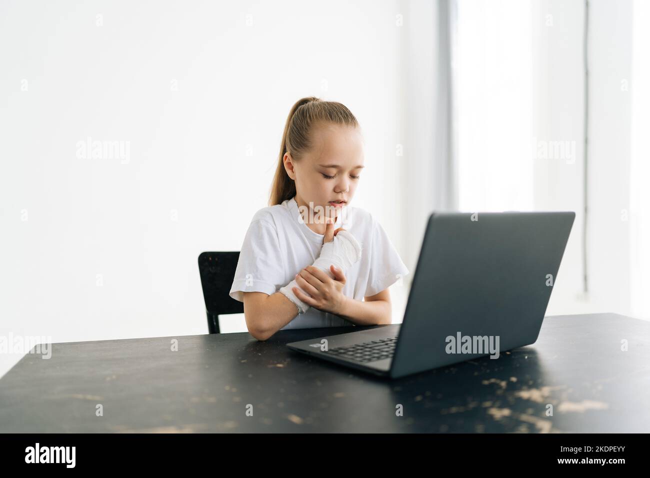 Suffering from pain little girl with broken hand wrapped in white ...