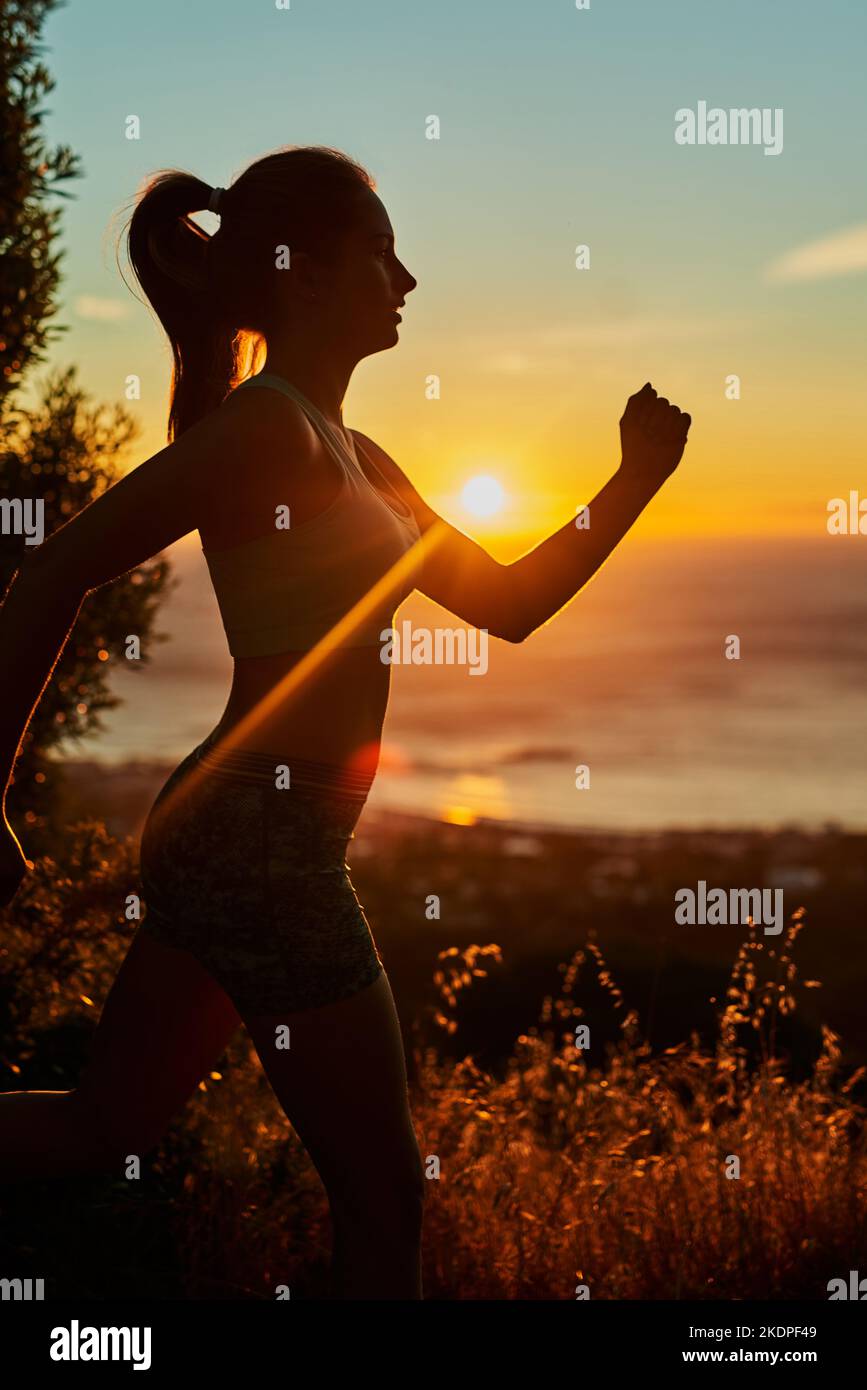 Taking the steps to better her life. a young woman running in the early ...