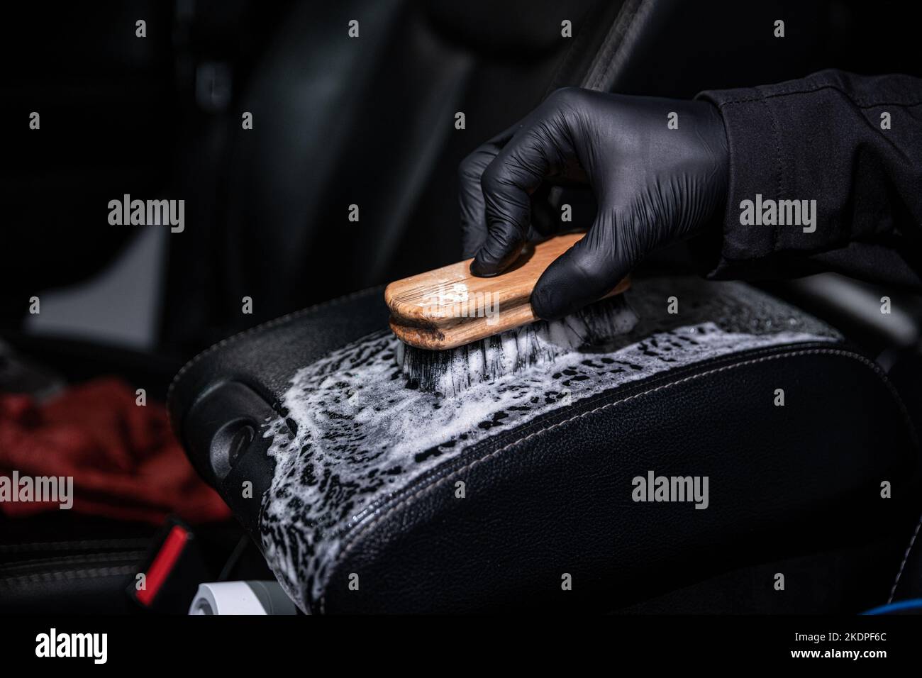 Car detailing or car wash studio worker cleans black leather car ...