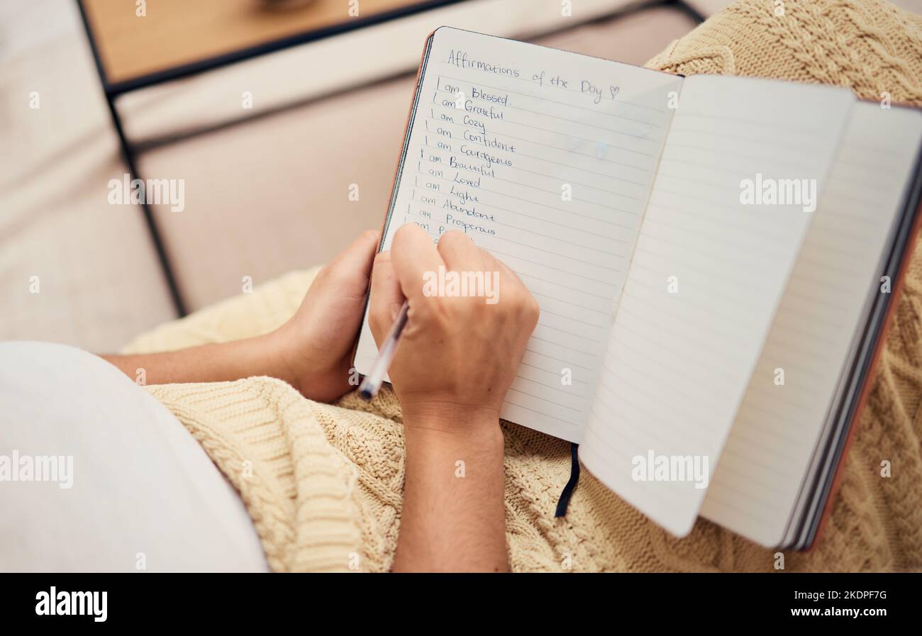 Book, hand and woman writing list in her notebook while relaxing with ...