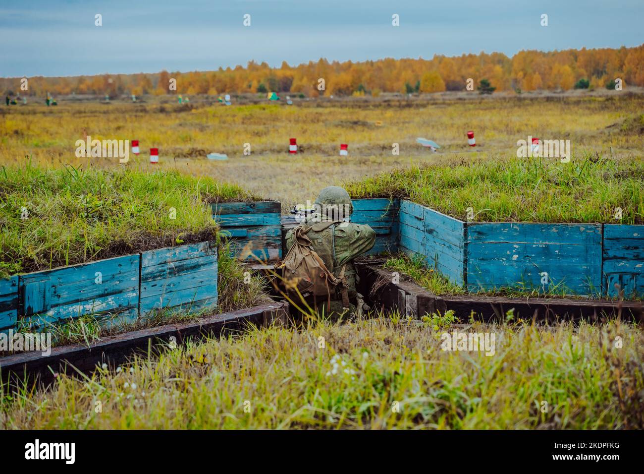 Shooting at the enemy from a trench. Taking cover in the field. A ...