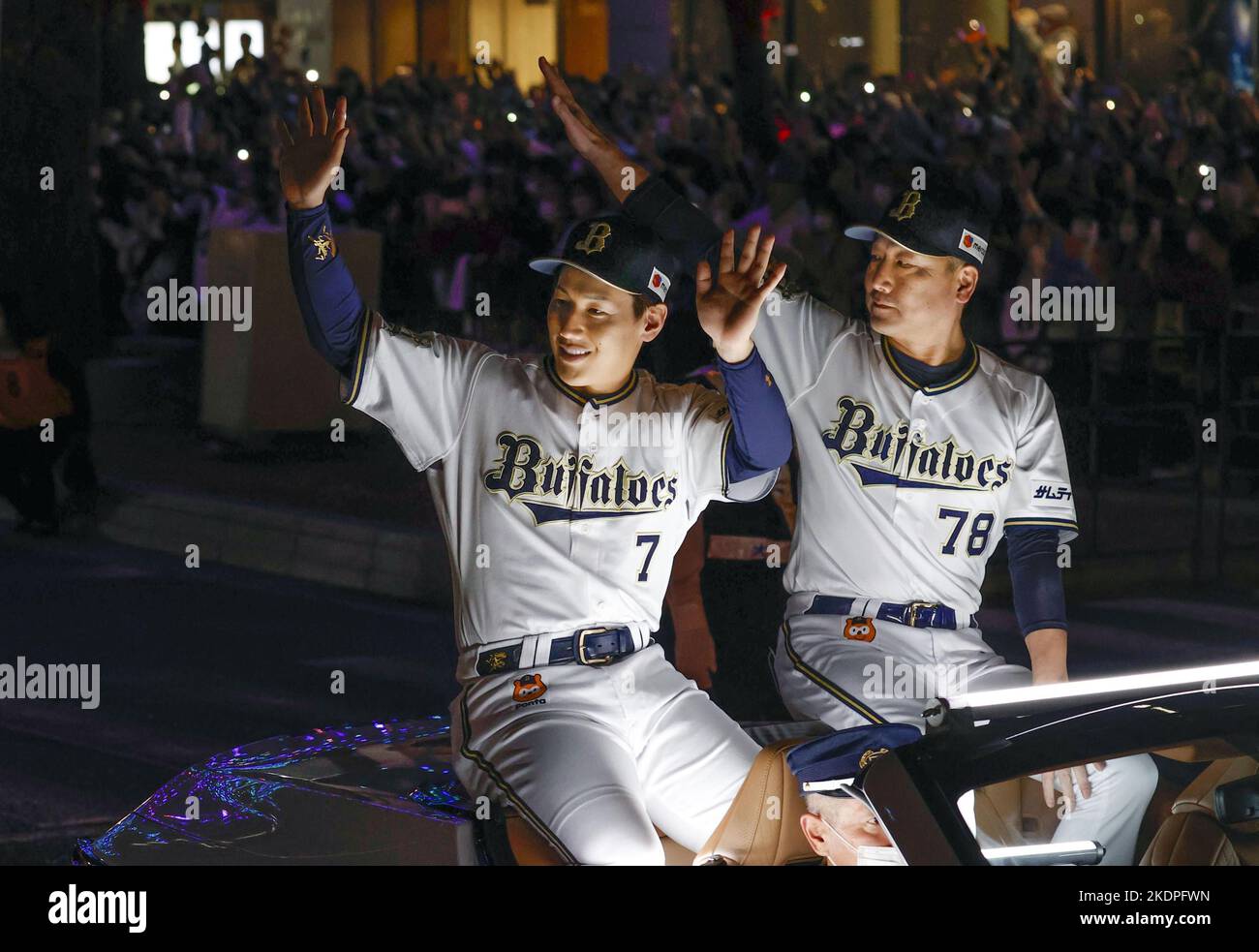 Orix Buffaloes manager Satoshi Nakajima (R) and player Masataka Yoshida wave to fans from a ...