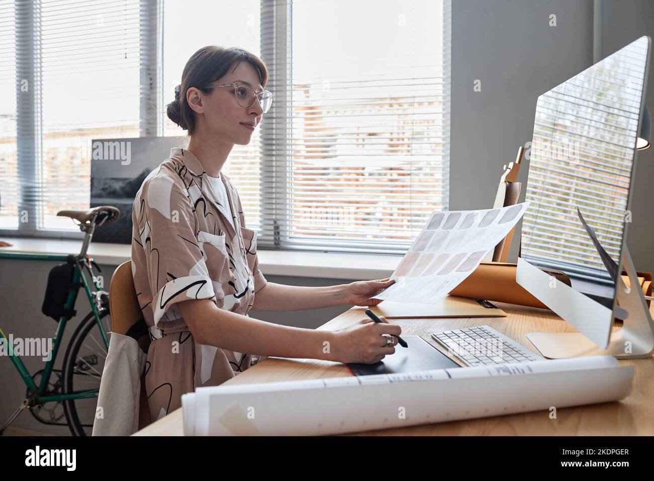 Side view portrait of young female designer focused at work in home ...